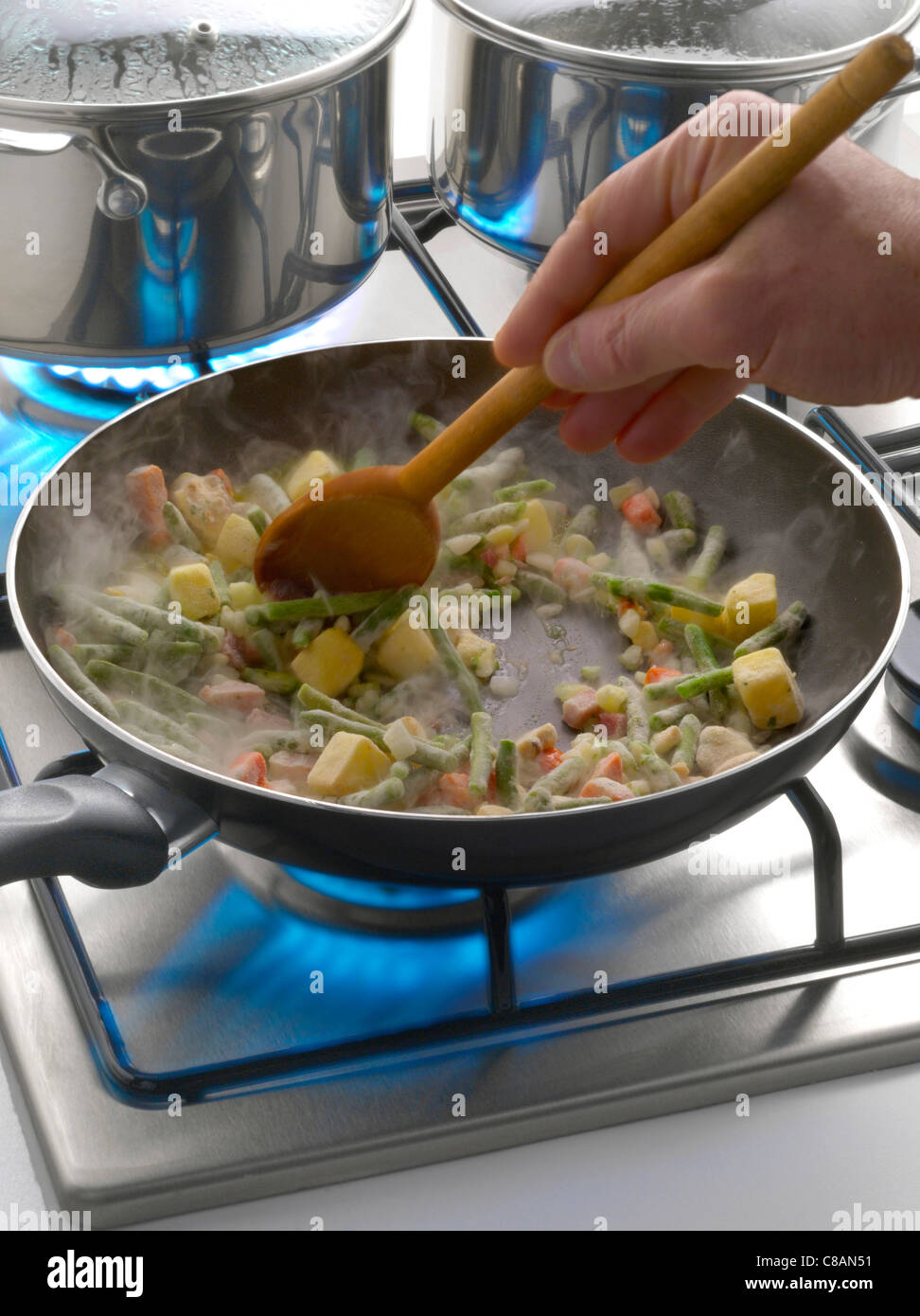 Cooking frozen vegetables in a frying pan Stock Photo - Alamy