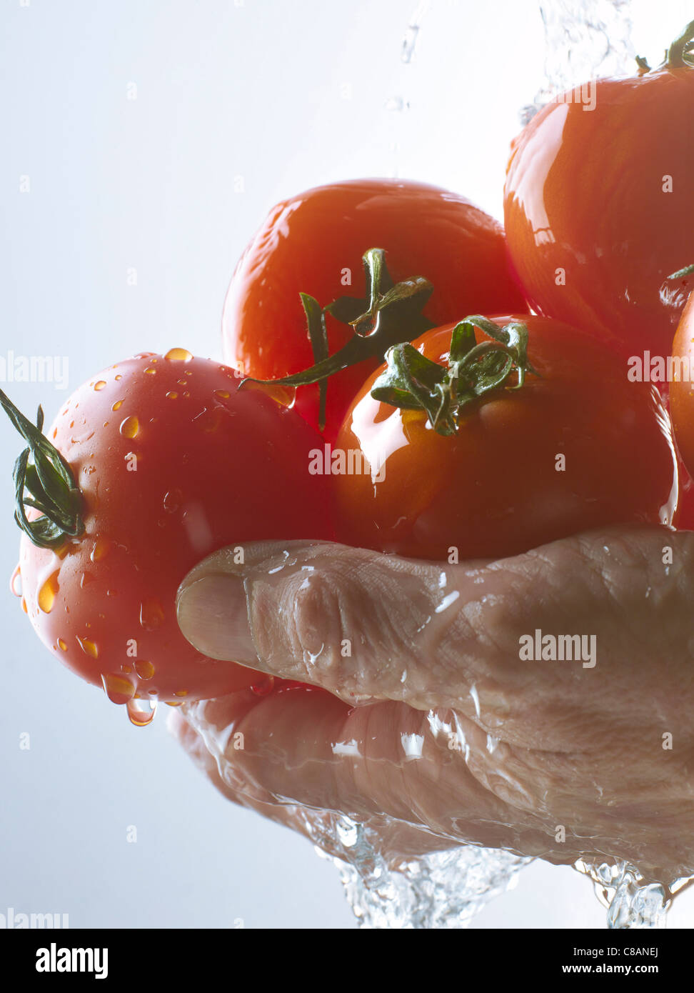 Rinsing tomatoes under the tap water Stock Photo - Alamy