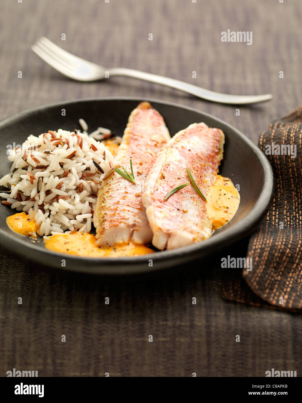 Red mullet fillets with creamy pepper sauce and rice Stock Photo - Alamy