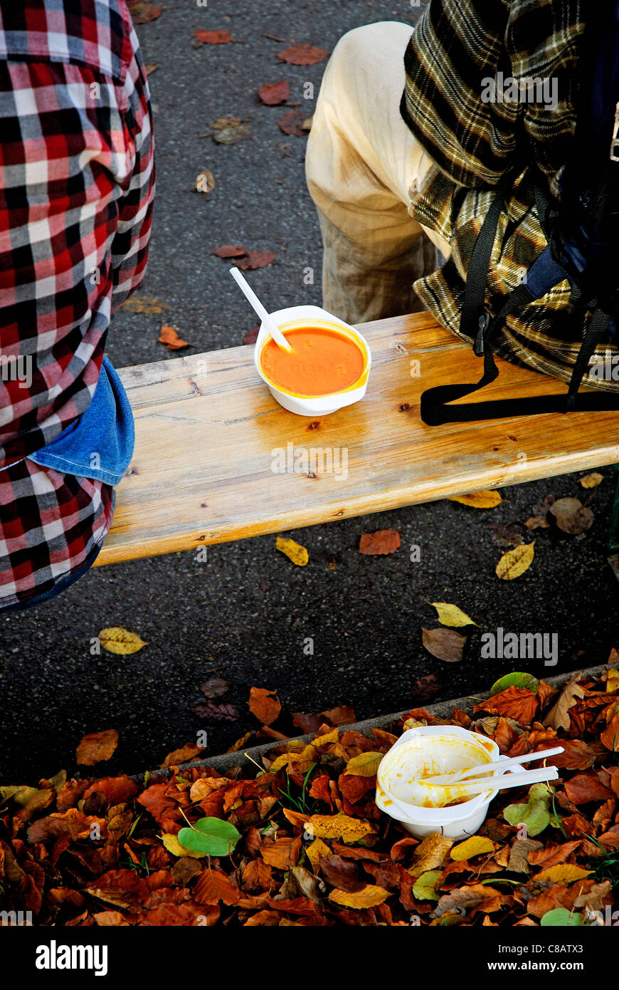 People eating soup on a bench Stock Photo - Alamy