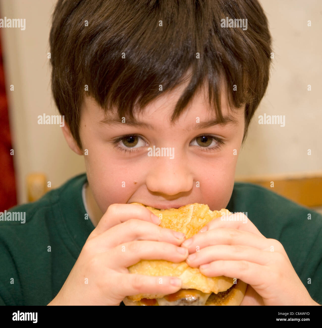 Boy eating a burger Stock Photo - Alamy