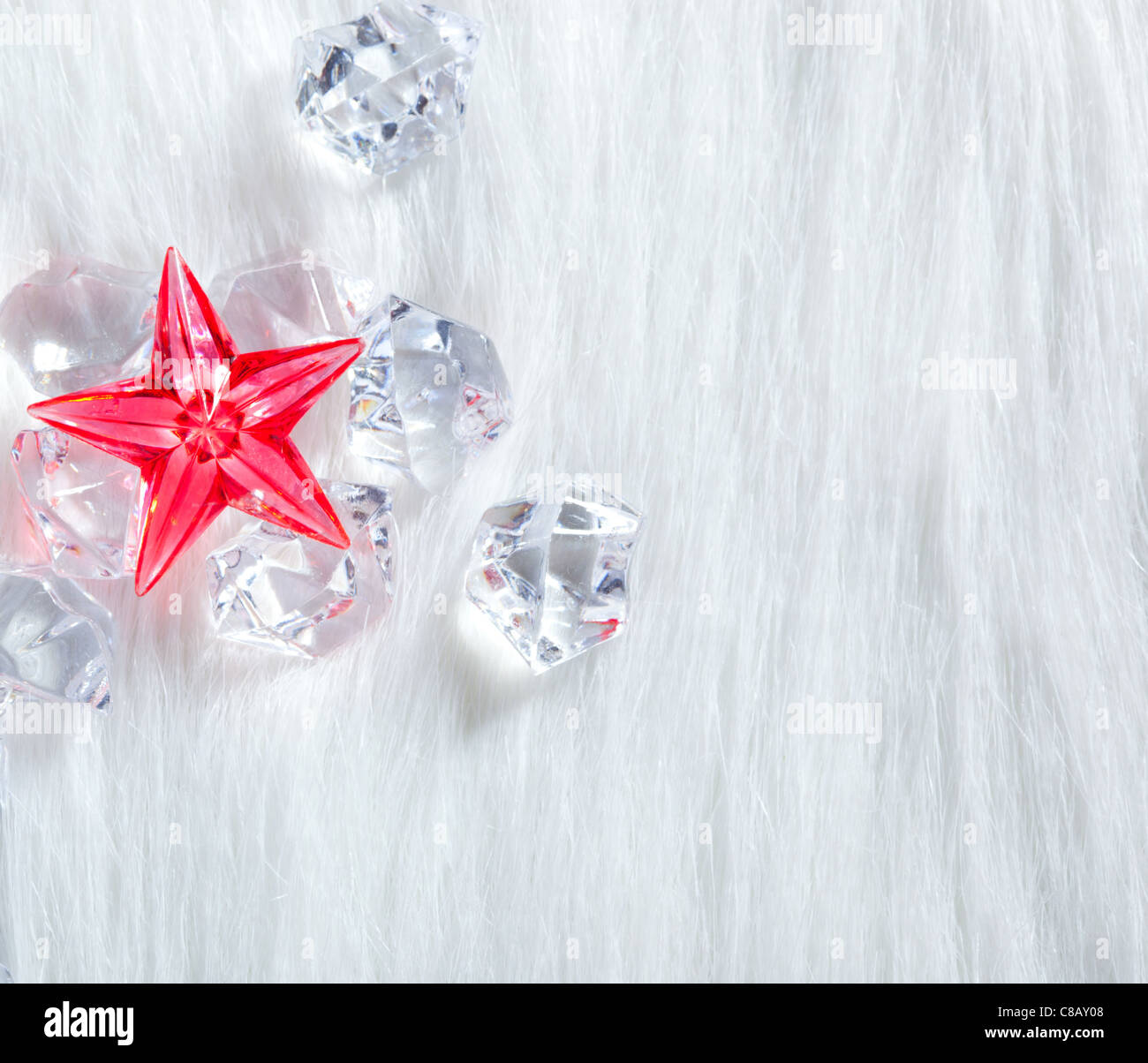 christmas red crystal star over ice cubes and white fur background ...