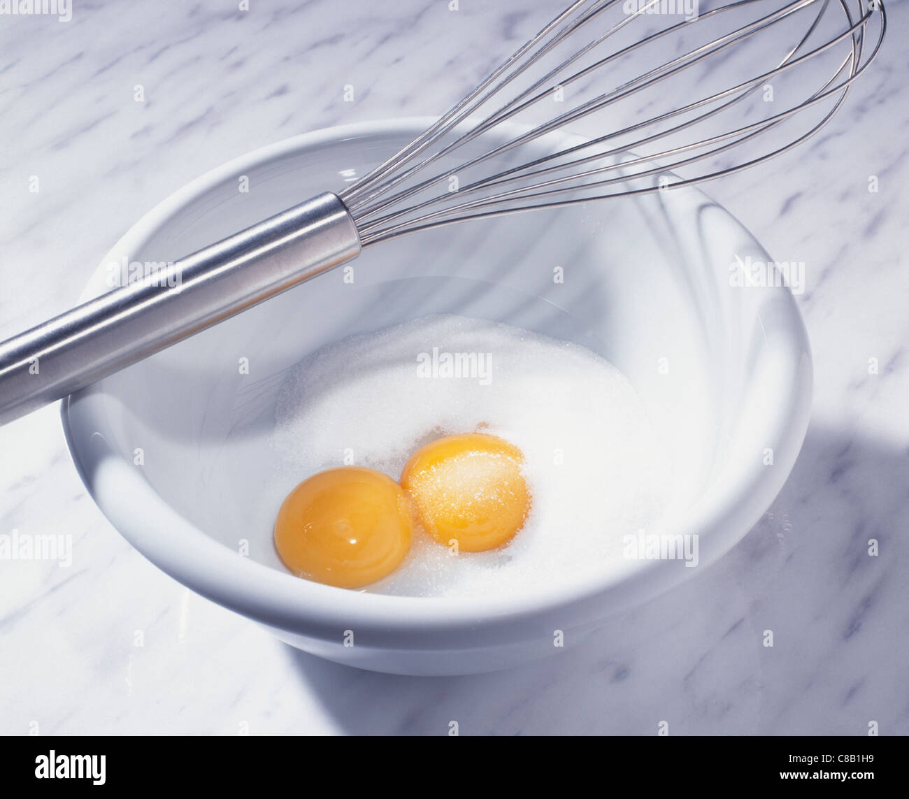Sugar and eggs in bowl with whisk Stock Photo - Alamy