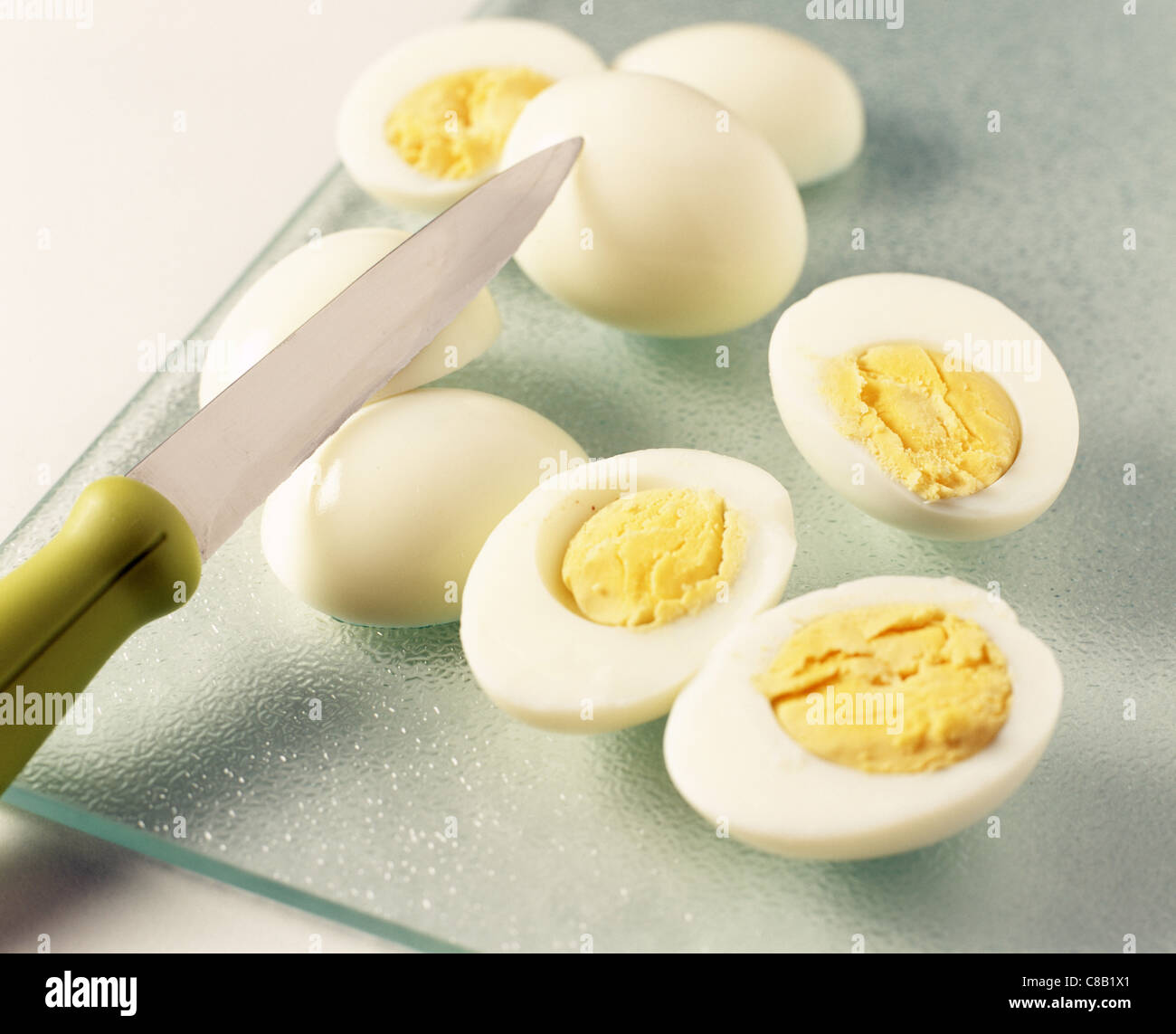 Boiled eggs with knife on chopping board Stock Photo - Alamy