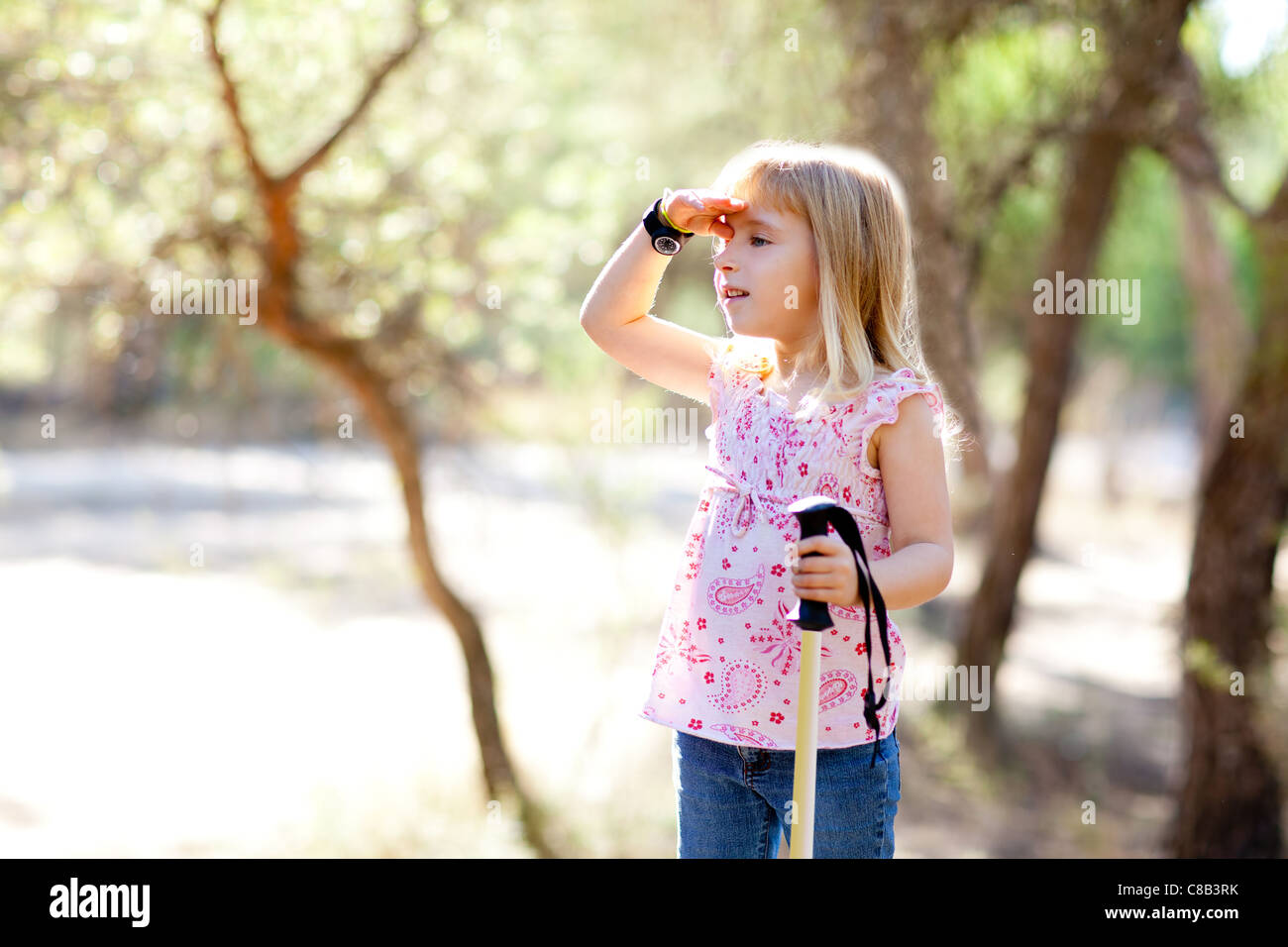 hiking kid girl searching hand in head in forest outdoor Stock Photo ...