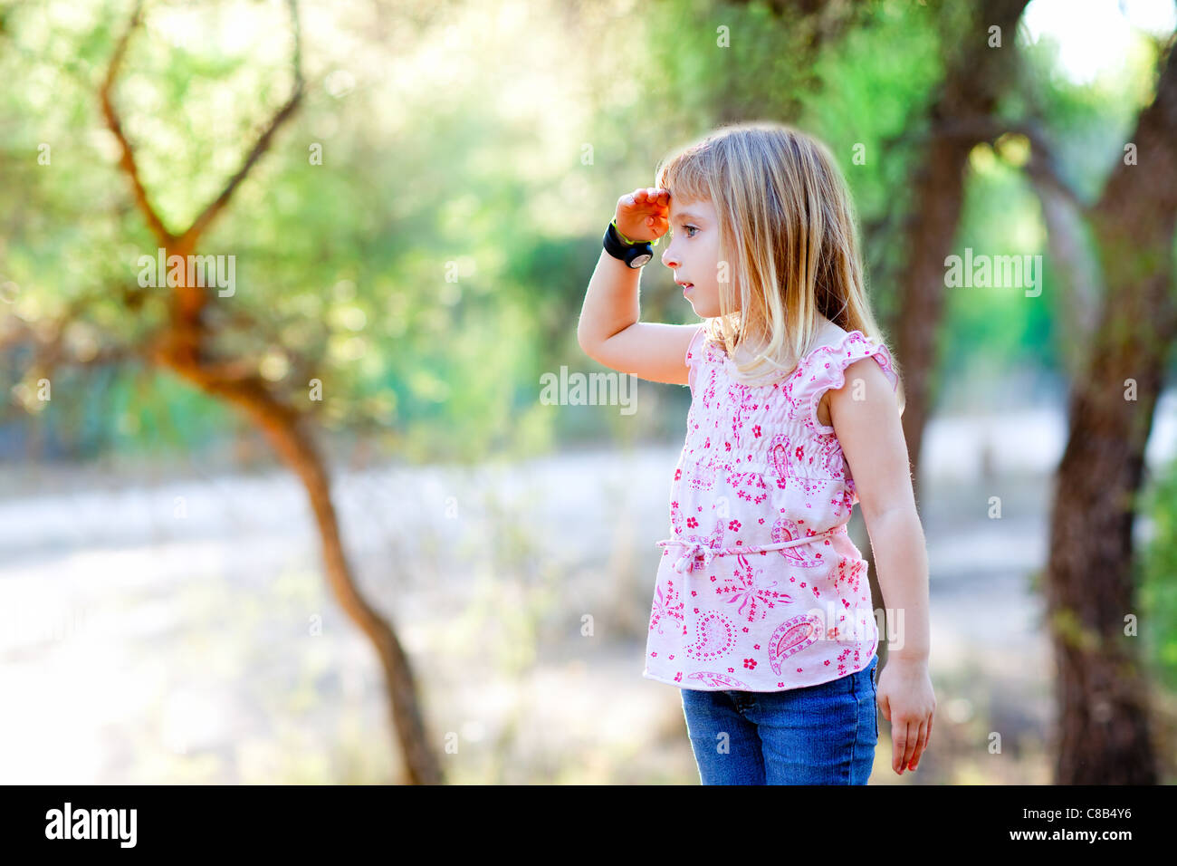 hiking kid girl searching hand in head in forest outdoor Stock Photo ...