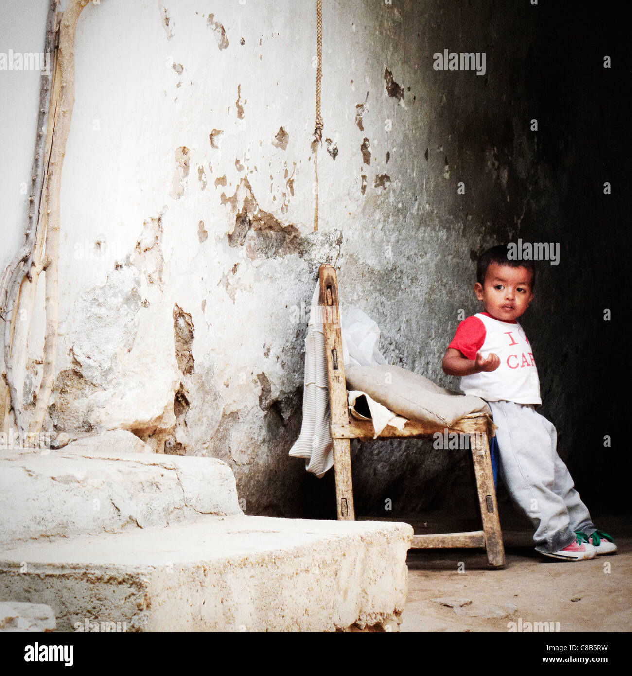 Argentinian boy leaning against a wooden chair Stock Photo - Alamy