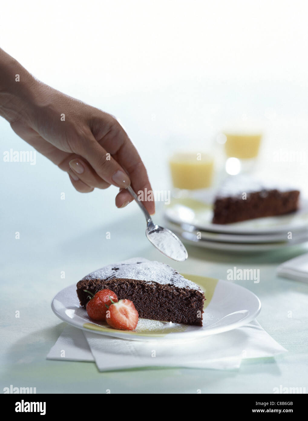 Sprinkling icing sugar on a slice of chocolate cake Stock Photo - Alamy
