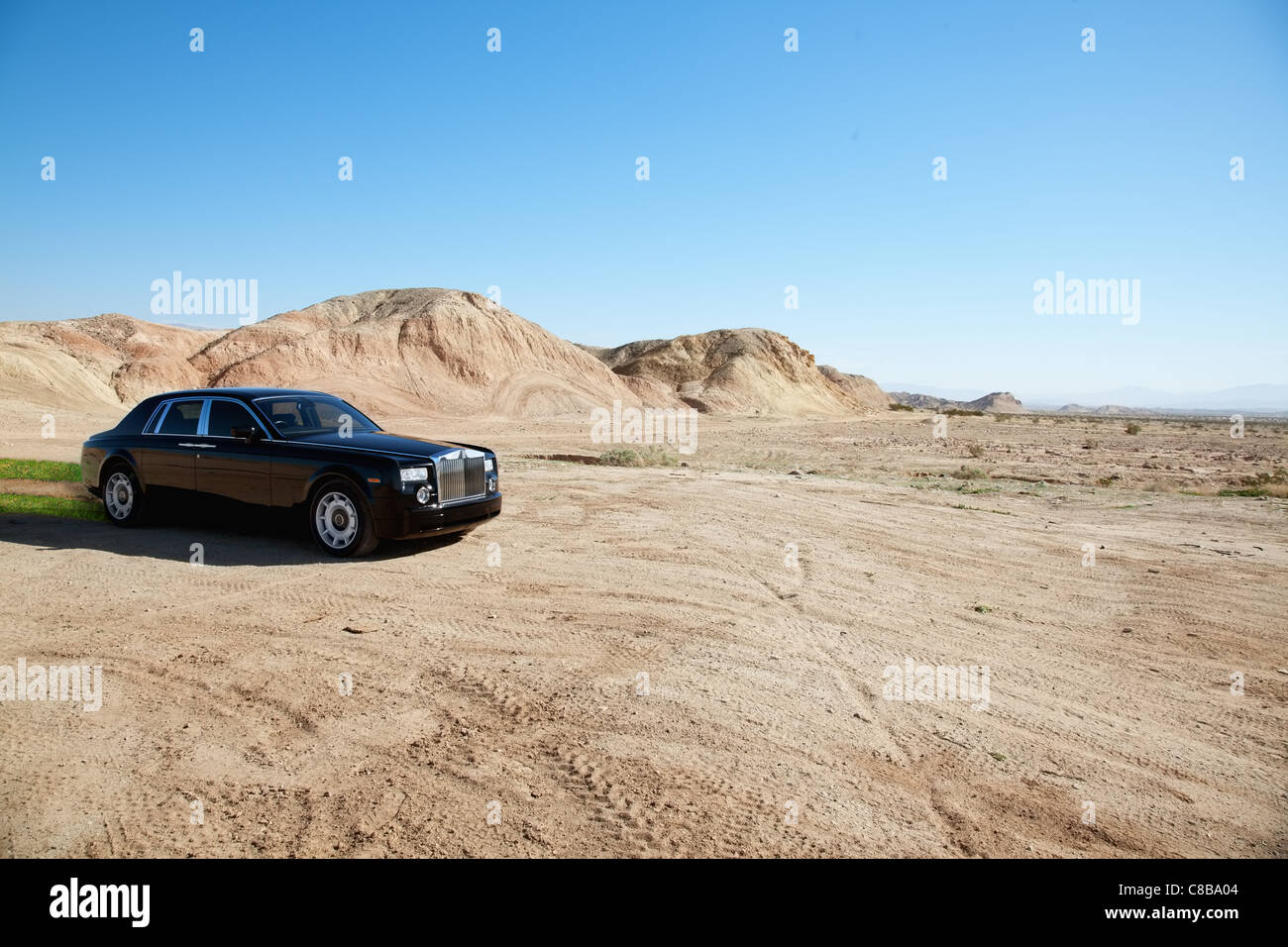 Black eco-friendly Rolls Royce car running off-road on unpaved road ...