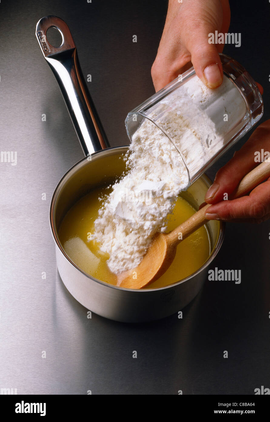 Pouring flour into pan of melted butter Stock Photo - Alamy