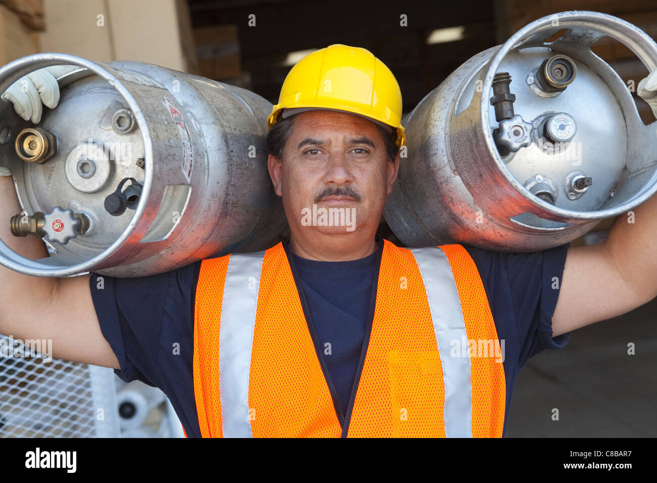 Portrait of a middle-aged man carrying cylinder Stock Photo - Alamy