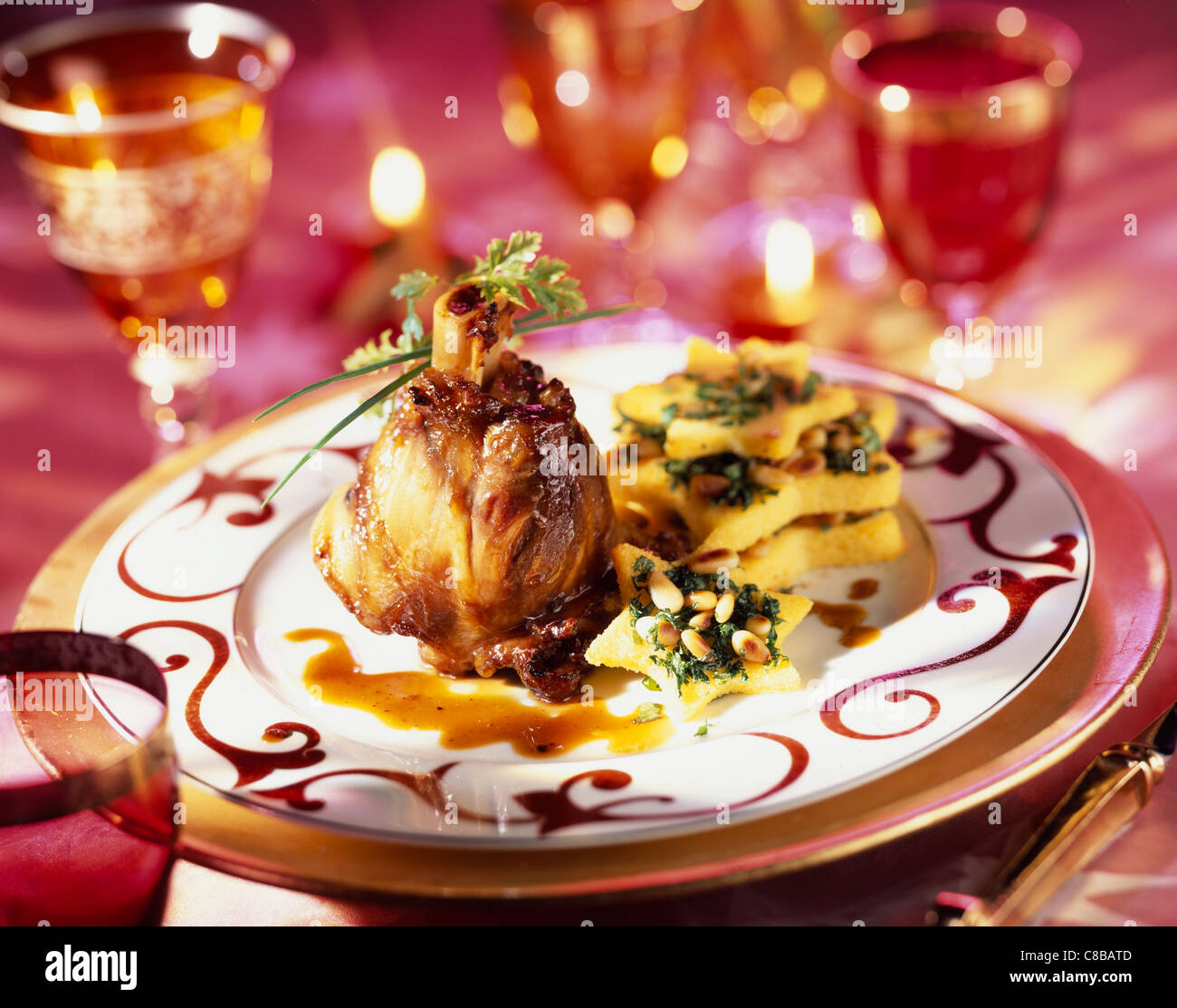 Caramelized knuckle of lamb with polenta stars Stock Photo - Alamy