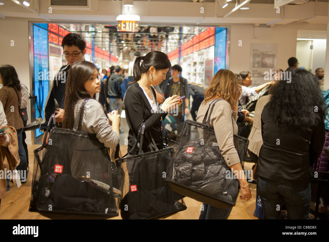 Customers shop at the grand opening of the Uniqlo Flagship store on ...