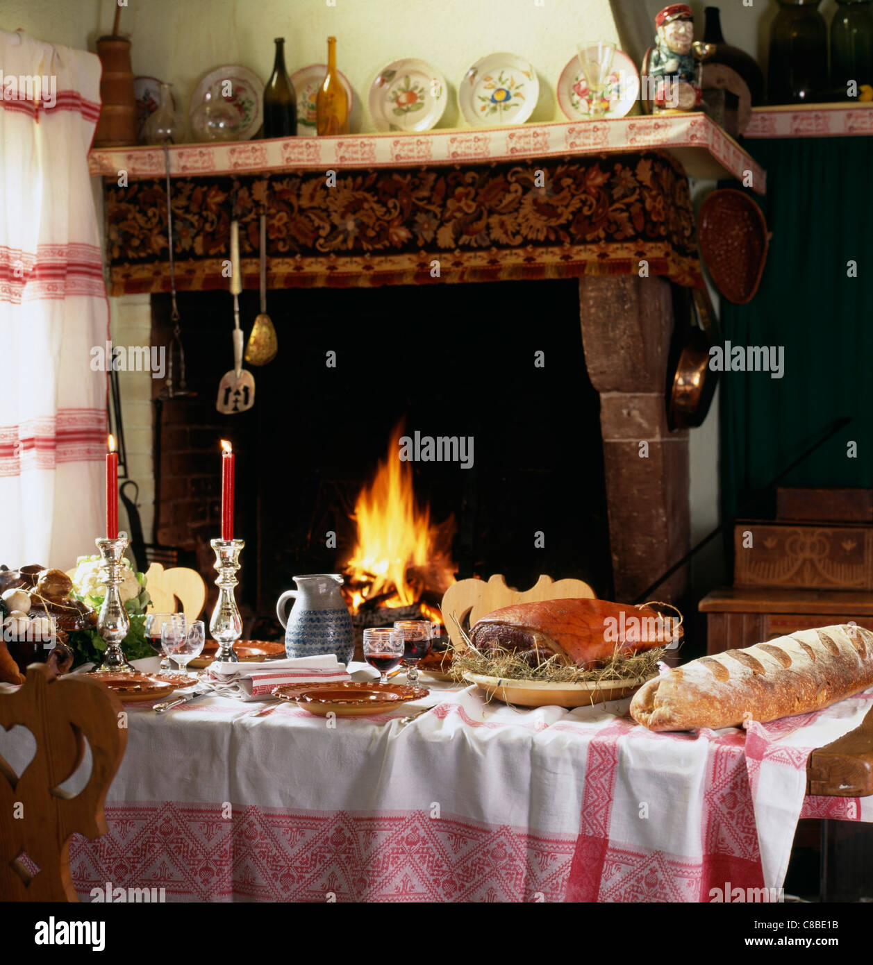 Set table with cured ham on bed of hay and fireplace Stock Photo - Alamy