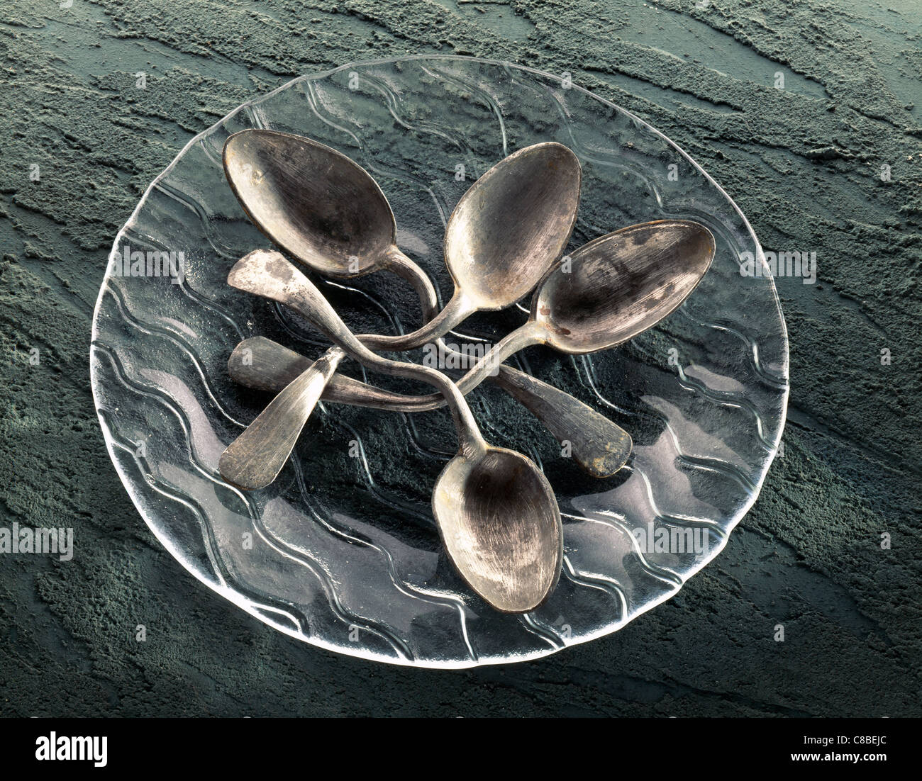 Bent spoons on plate Stock Photo - Alamy