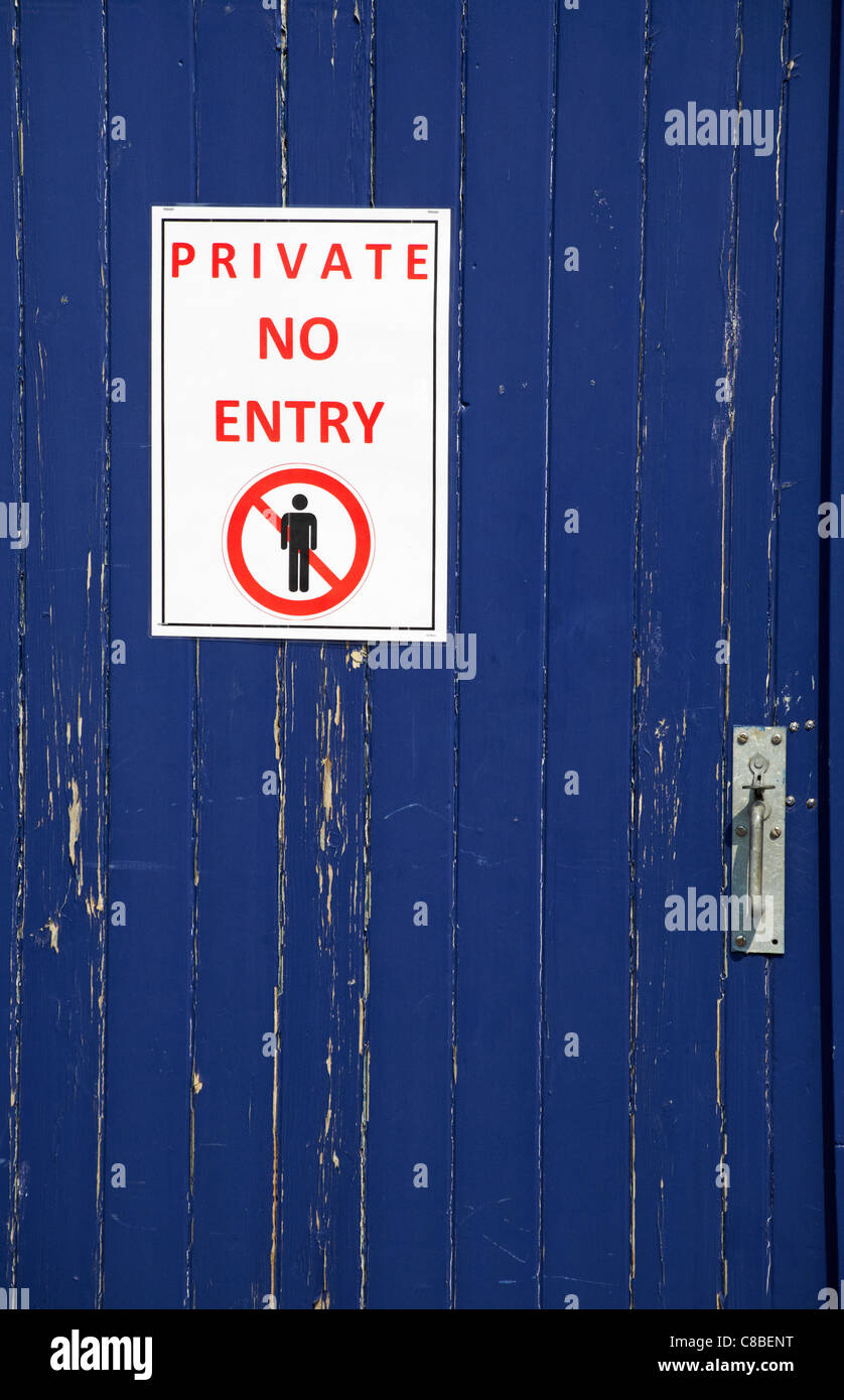 Private no entry sign notice on peeling blue painted door in UK Stock ...
