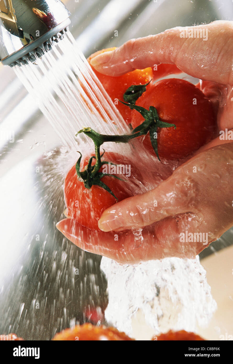rinsing tomatoes under tap Stock Photo - Alamy
