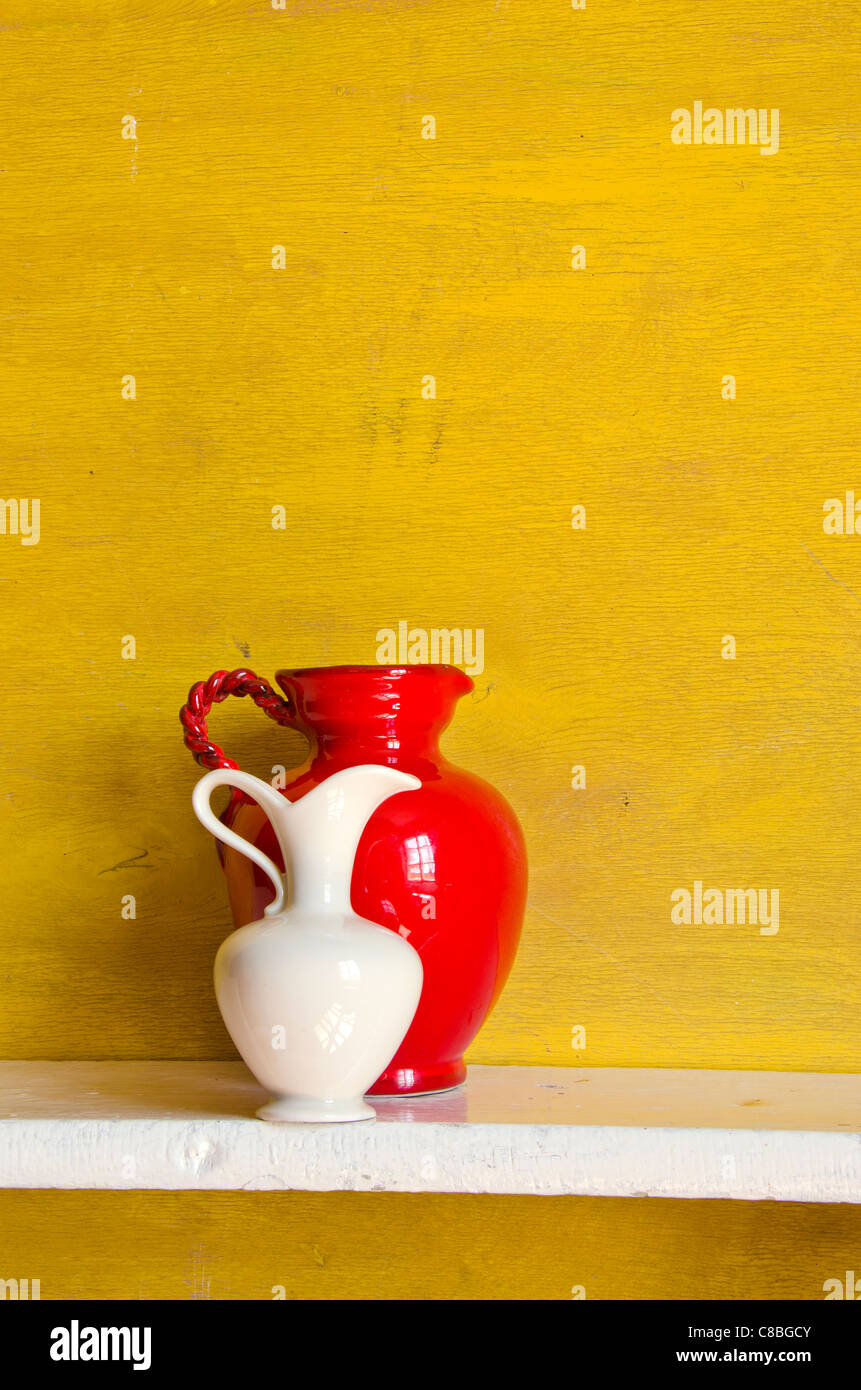 two red and white pitchers on yellow background Stock Photo - Alamy