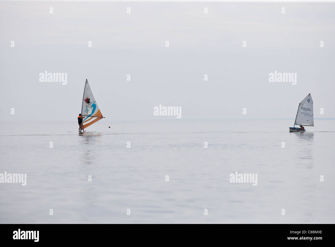 Surfboard and little sailing boat on lake Peipsi Stock Photo - Alamy