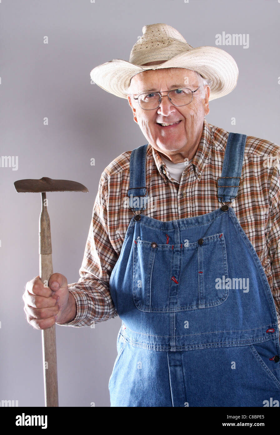 A farmer holding a farming tool Stock Photo - Alamy