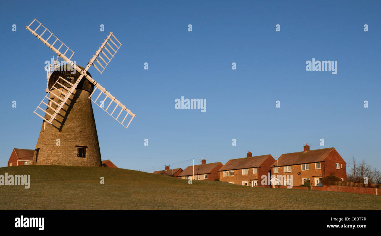 Photograph of a traditional windmill sited close to a residential area ...