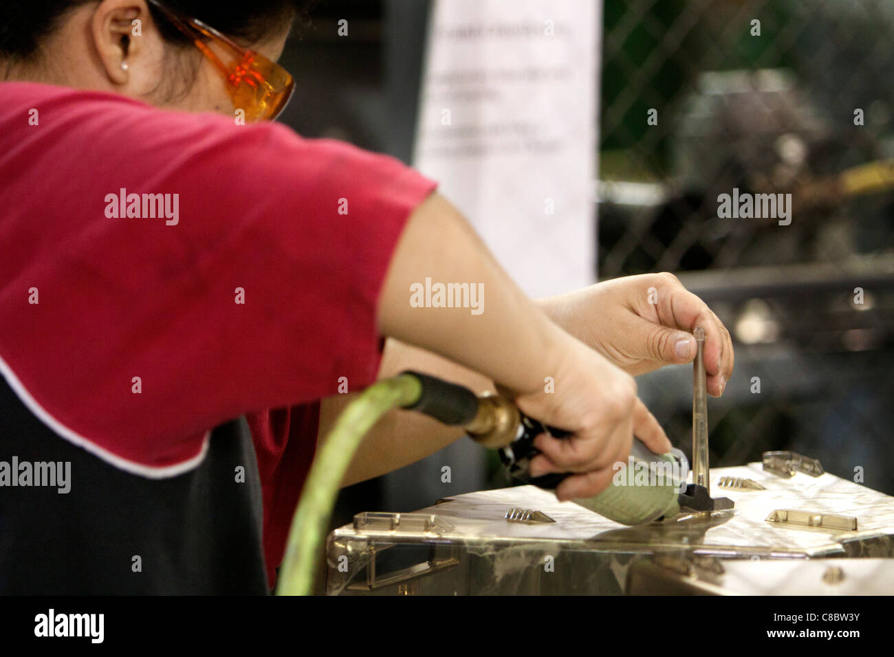 A woman finished a plastic product at a plastic injection molding plant ...