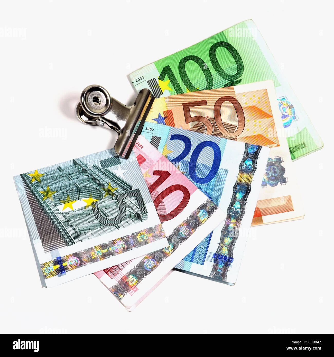 Folded Euro banknotes from 5 to 100 Euro in a paper clip on white ...
