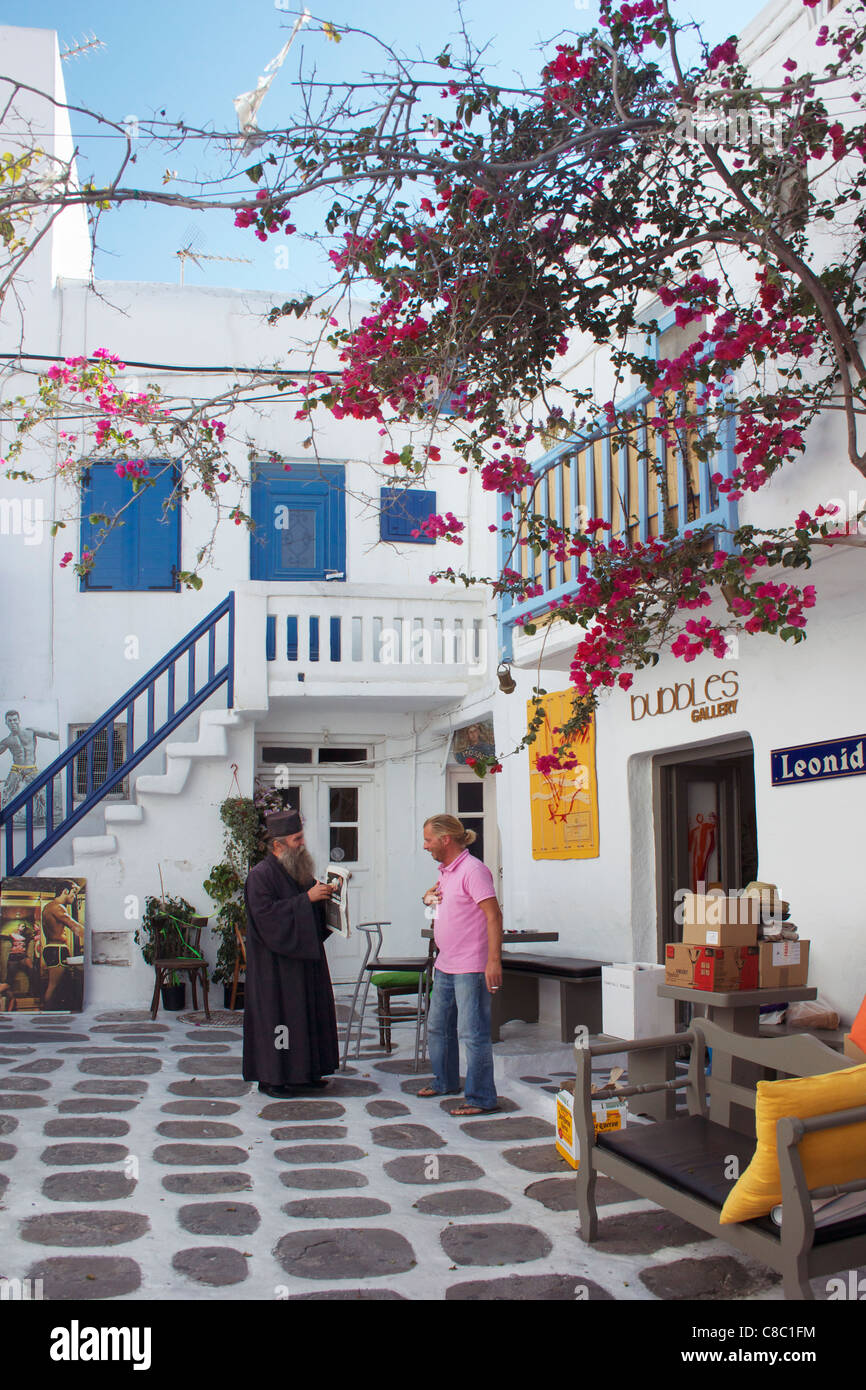 Greek orthodox priest chatting with a shop keeper in Mykonos, Greece ...