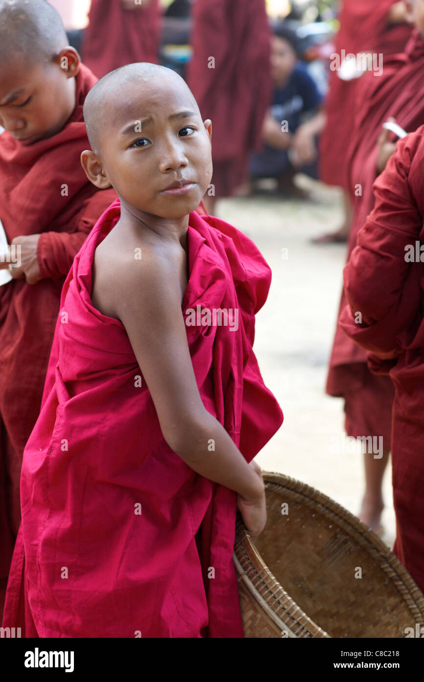 An unidentified young novice monk carrying basket Stock Photo - Alamy