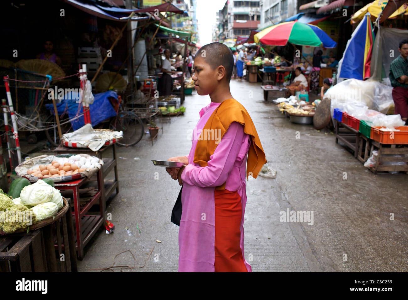 Young nun wearing traditional robe in the streets begging for alms ...