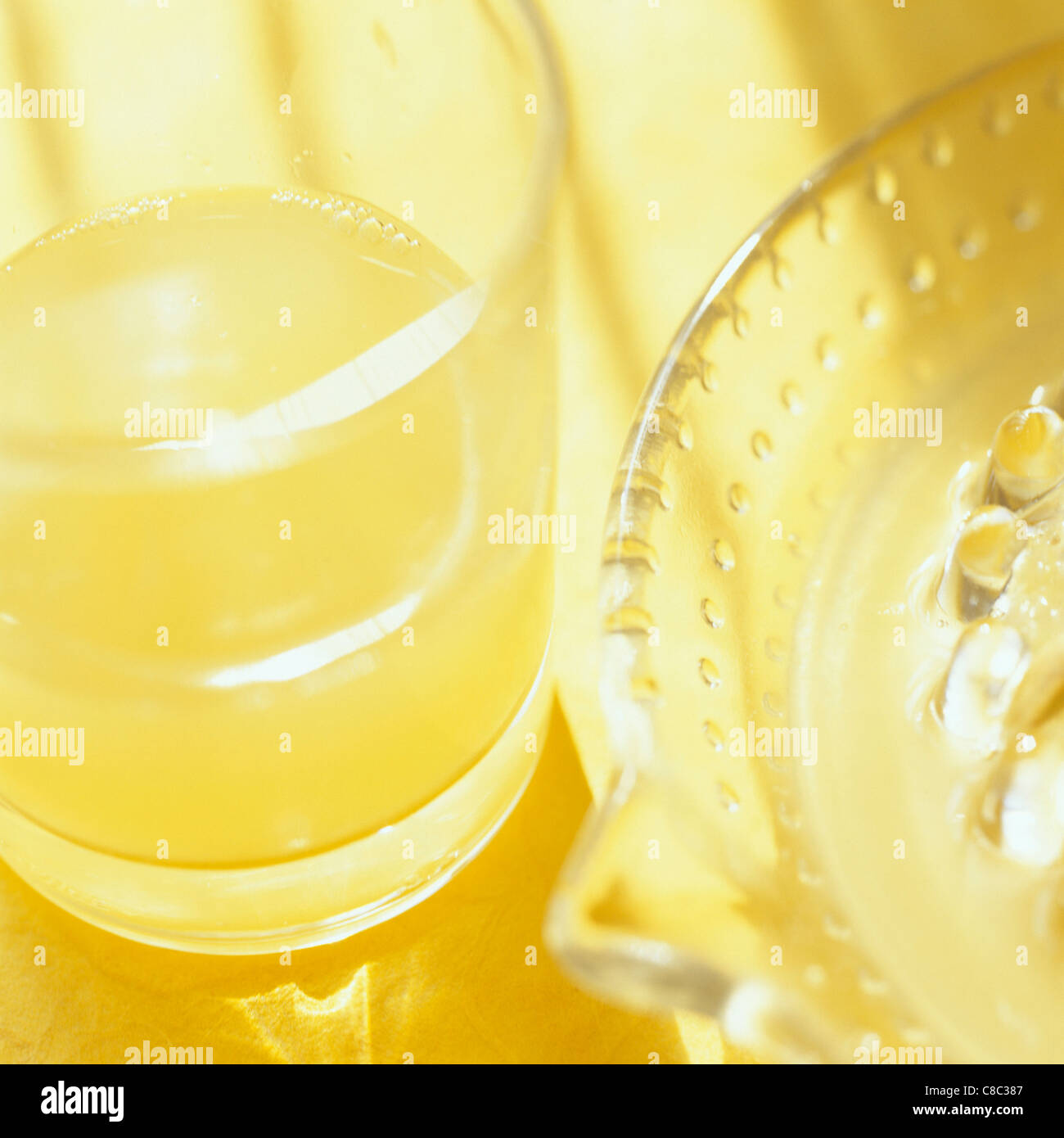 glass of lemon juice with squeezer Stock Photo - Alamy