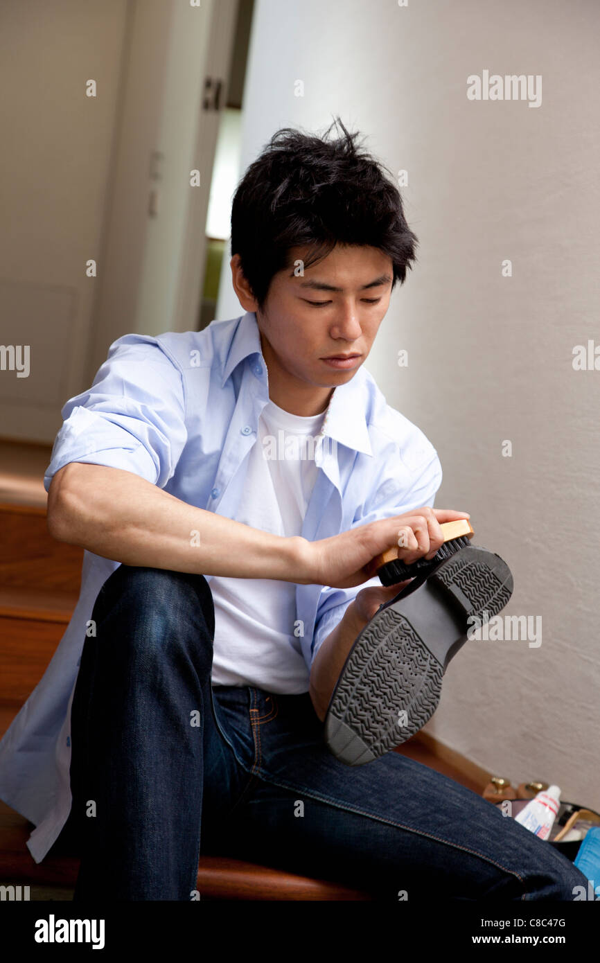 Mid adult man polishing shoe Stock Photo - Alamy