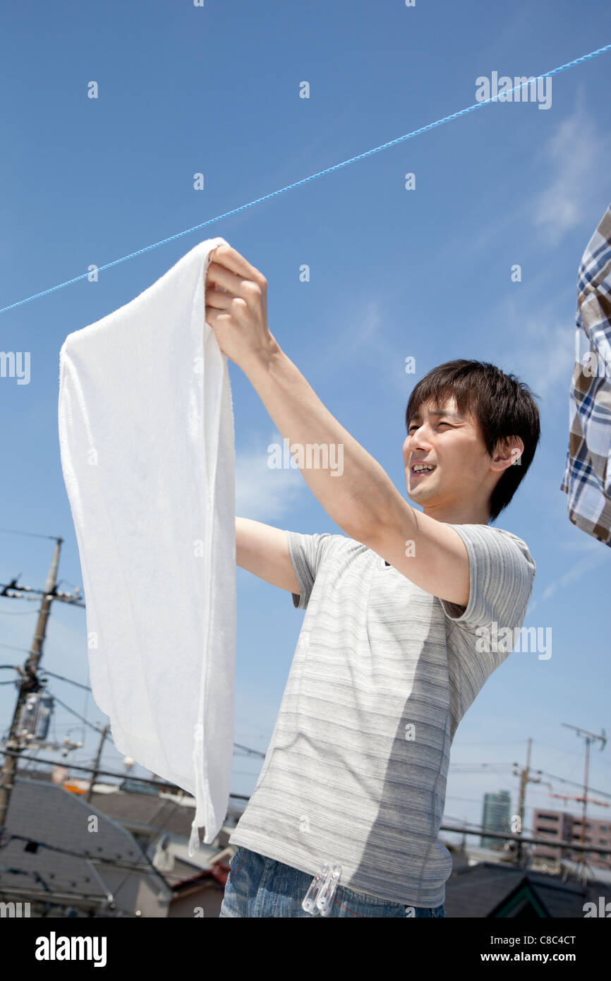 Young man hanging out laundry Stock Photo - Alamy