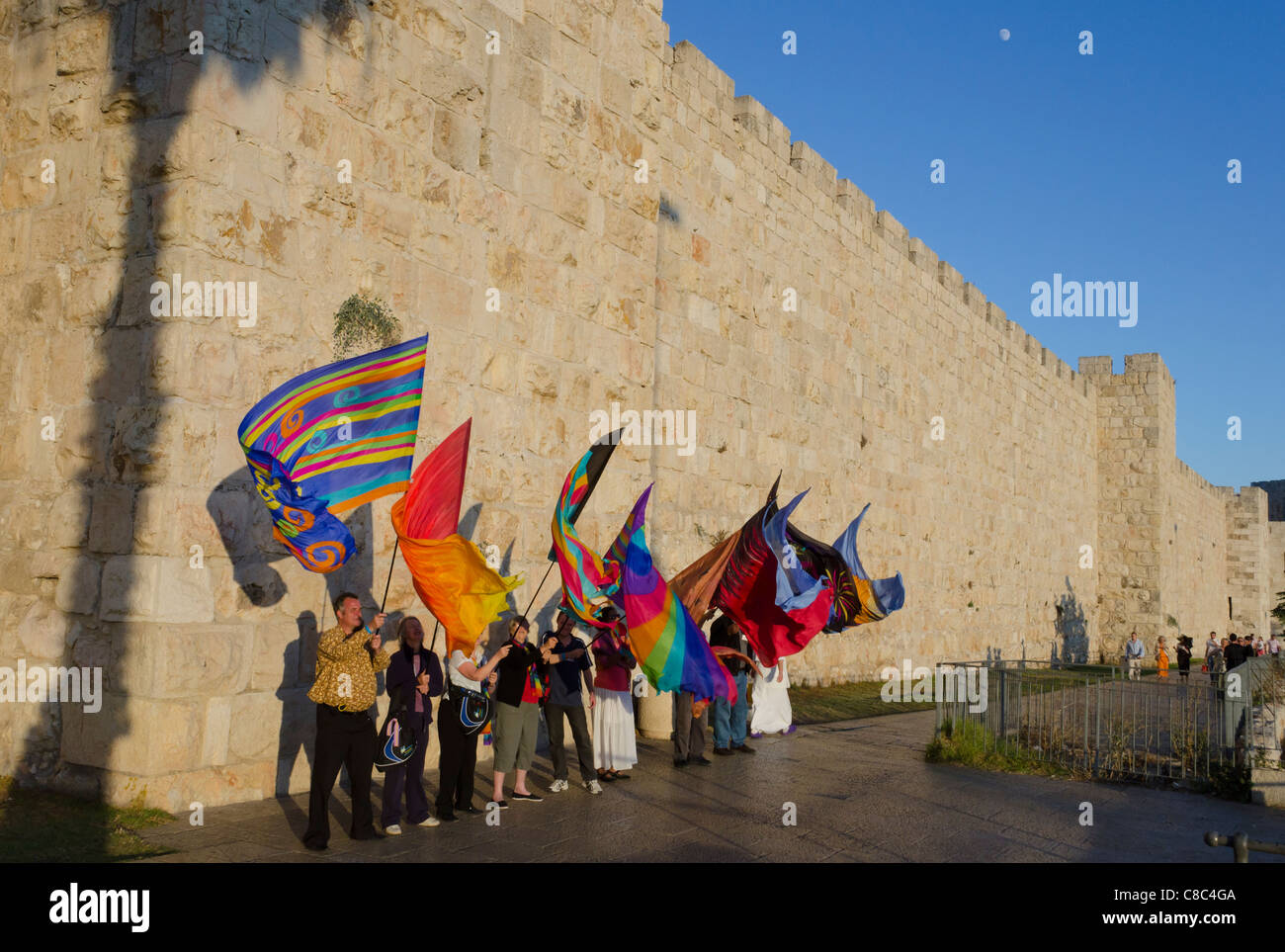 American pilgrims walking with colourful flags along the city walls ...