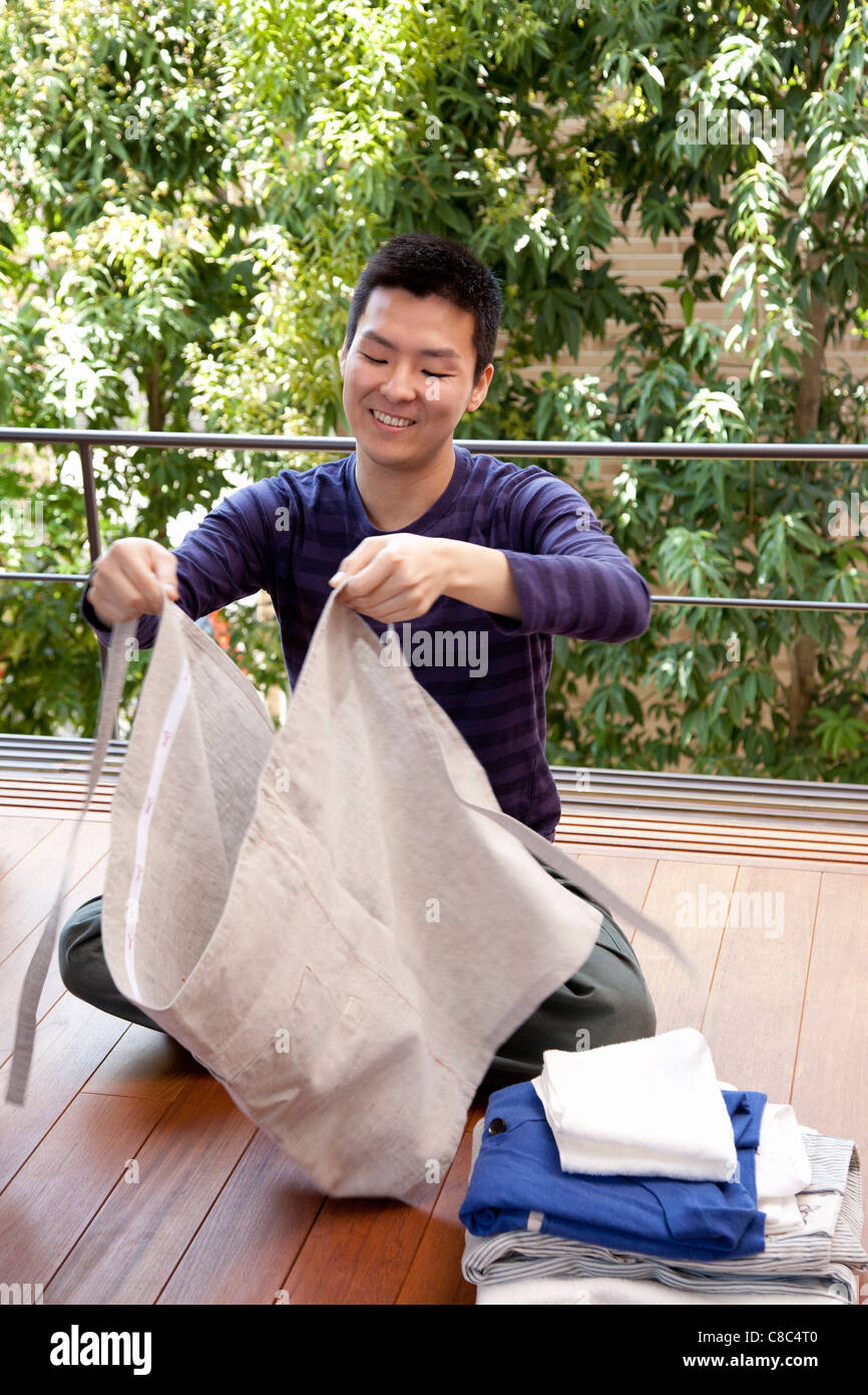 Young man folding laundry Stock Photo - Alamy