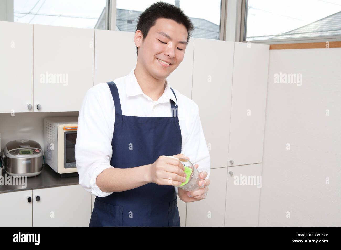 Young man washing glass Stock Photo - Alamy