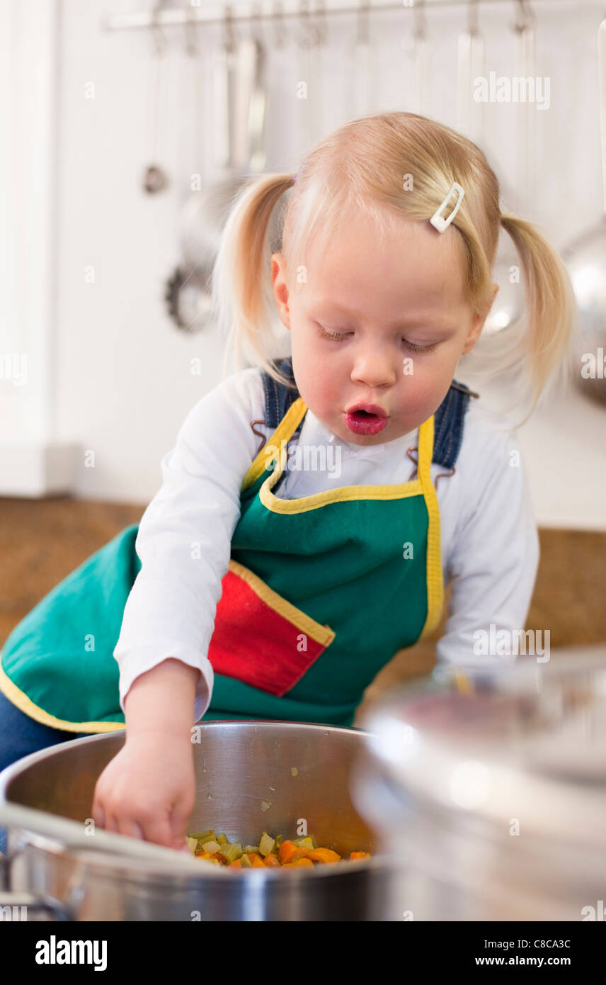 Toddler girl cooking in kitchen Stock Photo - Alamy