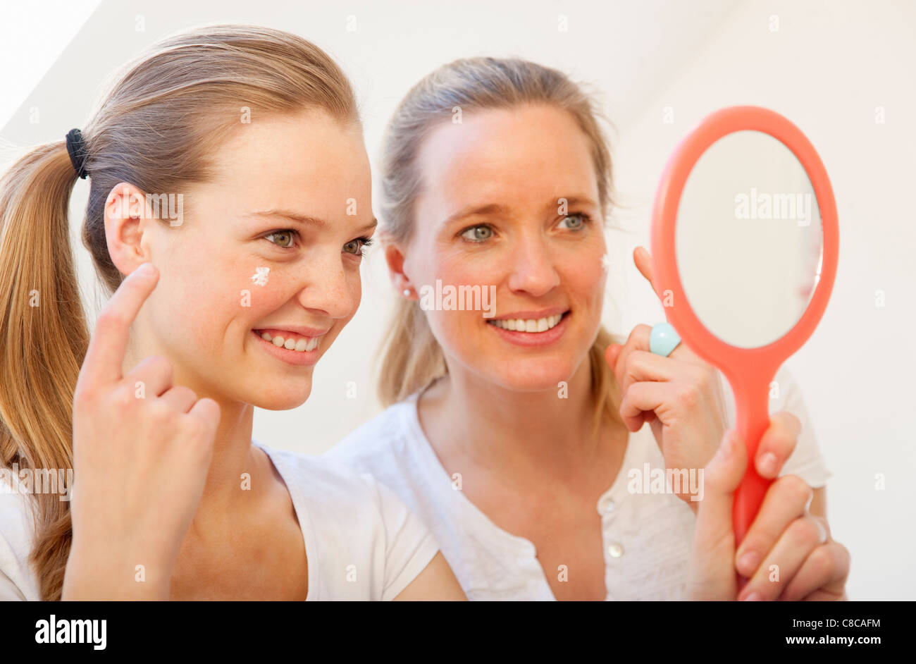 Mother and daughter applying makeup Stock Photo - Alamy