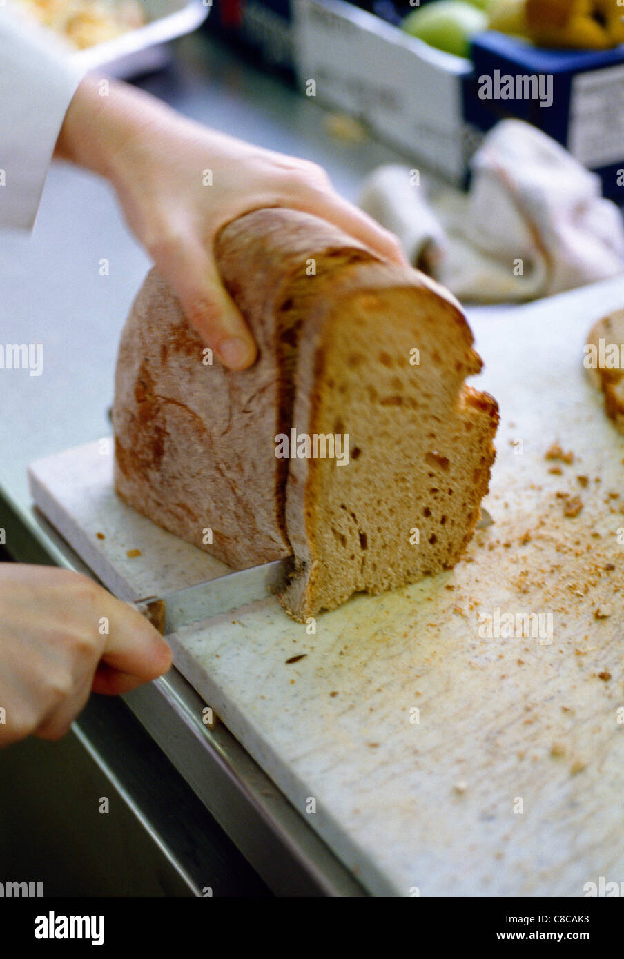 Slicing bread with hands and knife Stock Photo - Alamy