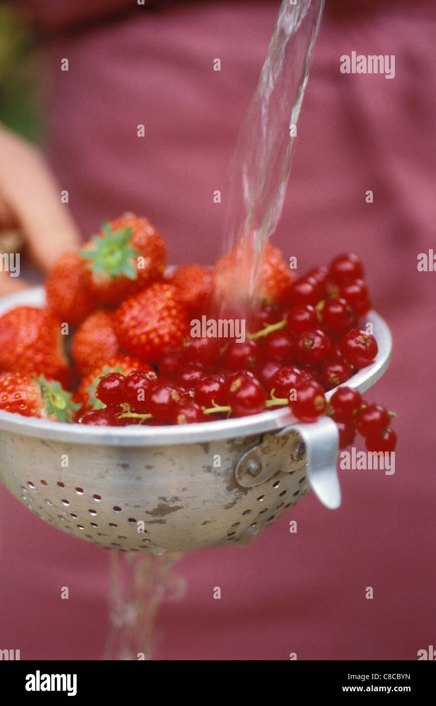 Rinsing summer fruit under the tap Stock Photo - Alamy