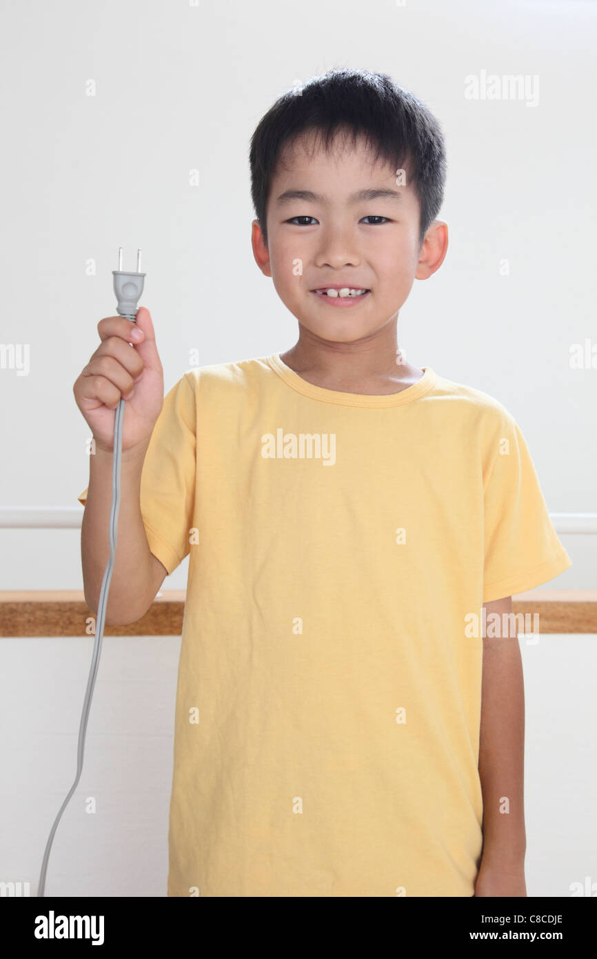 Boy holding and showing plug Stock Photo - Alamy