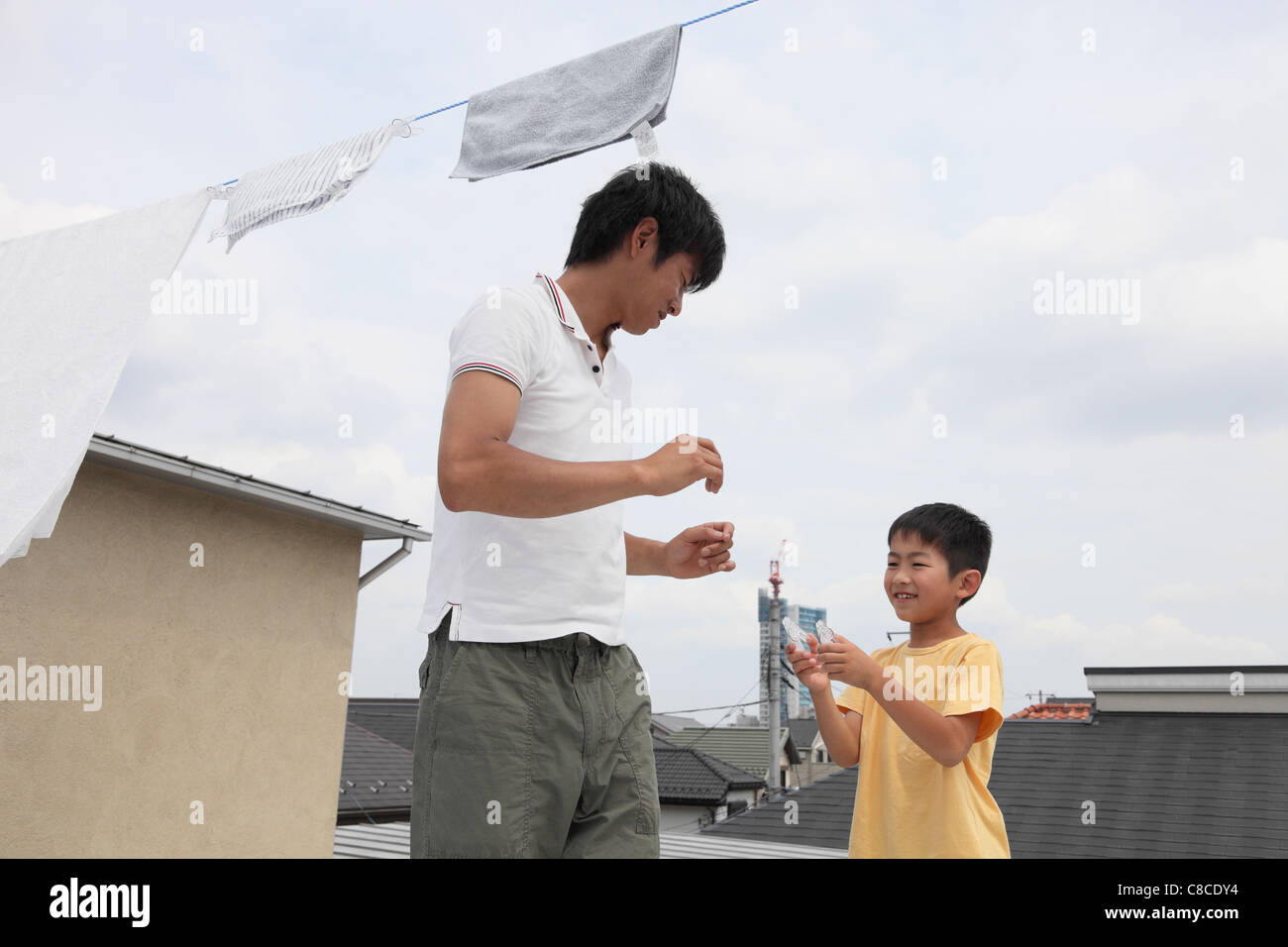 Father and son hanging out laundry Stock Photo - Alamy