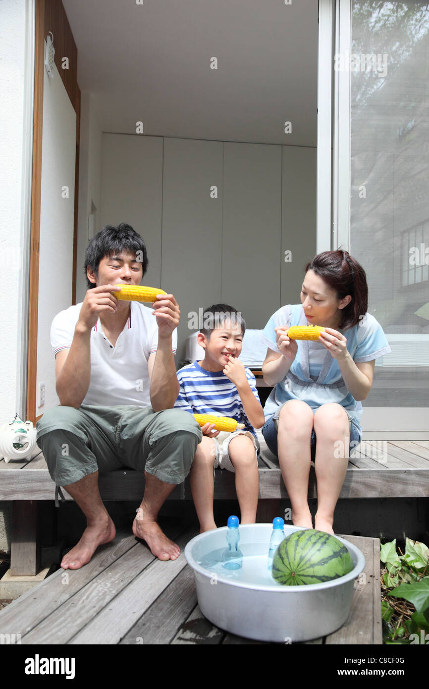 Family eating corn at verandah Stock Photo - Alamy