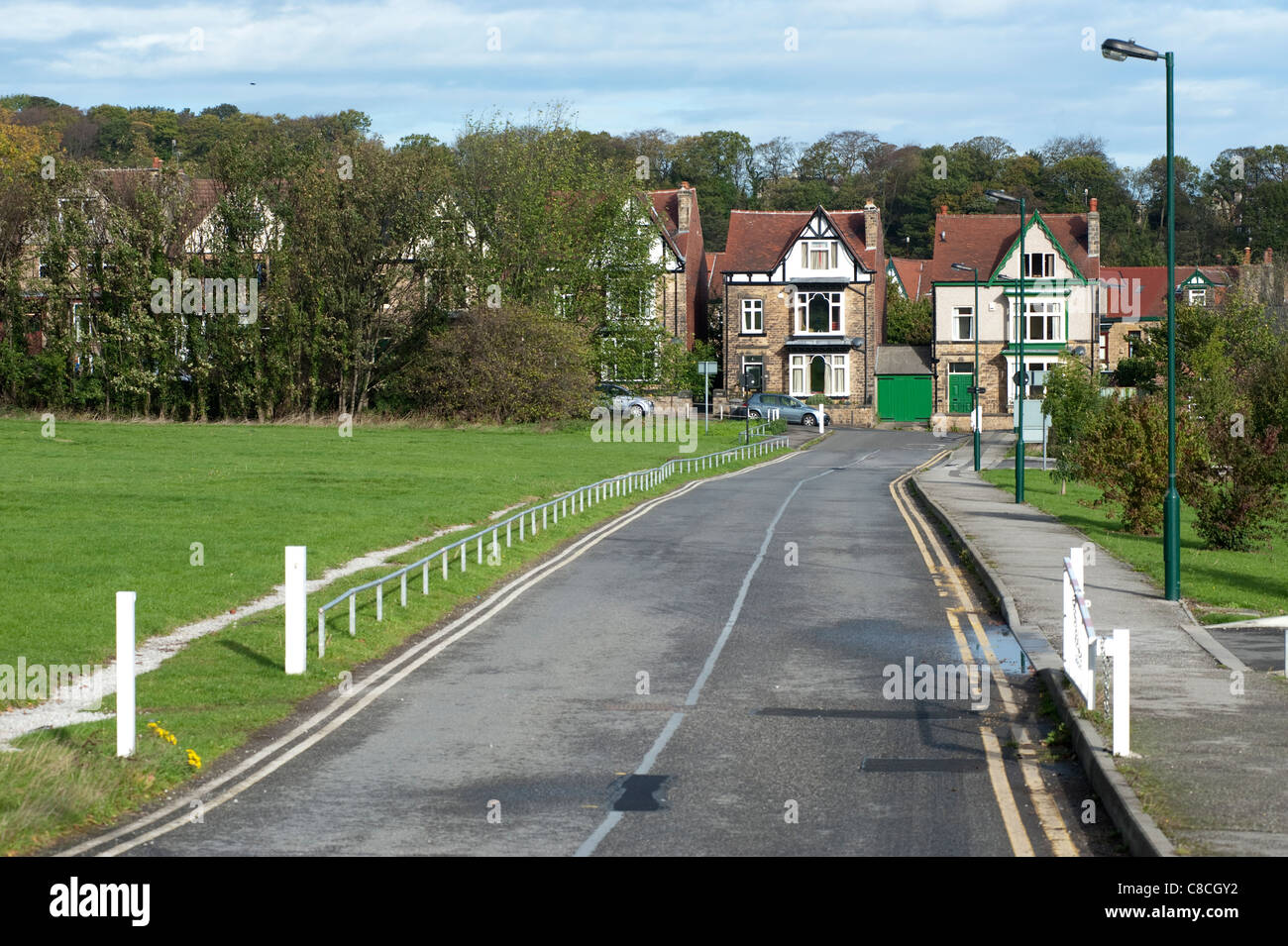 Metal road barrier across a tarmacked driveway to restrict traffic at ...
