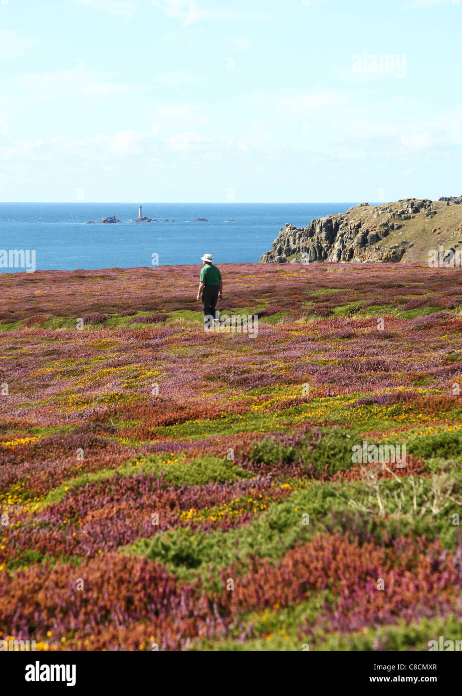 A man walking at Gwennap Head with The Longships Lighthouse in the ...