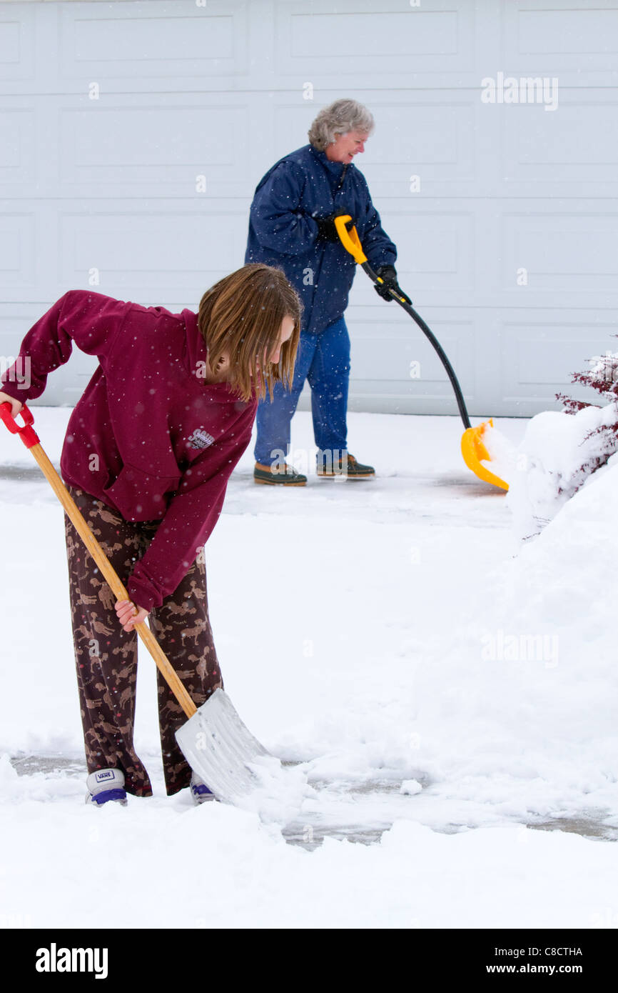 People shovel winter snow off of a driveway in Boise, Idaho, USA Stock ...