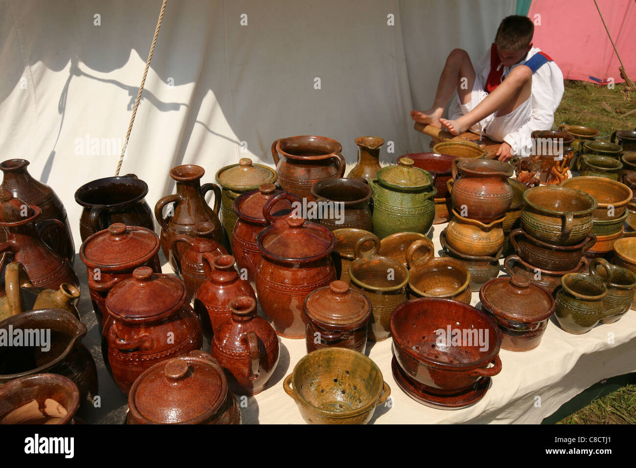 Vendor sells ceramic pottery at the medieval market during the re ...