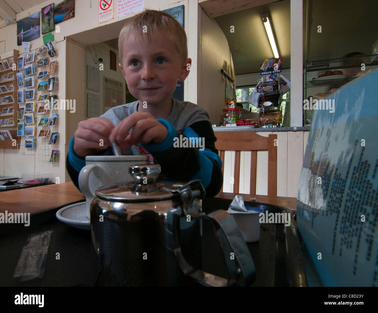 Relaxed boy pouring sugar into hot drink Stock Photo - Alamy