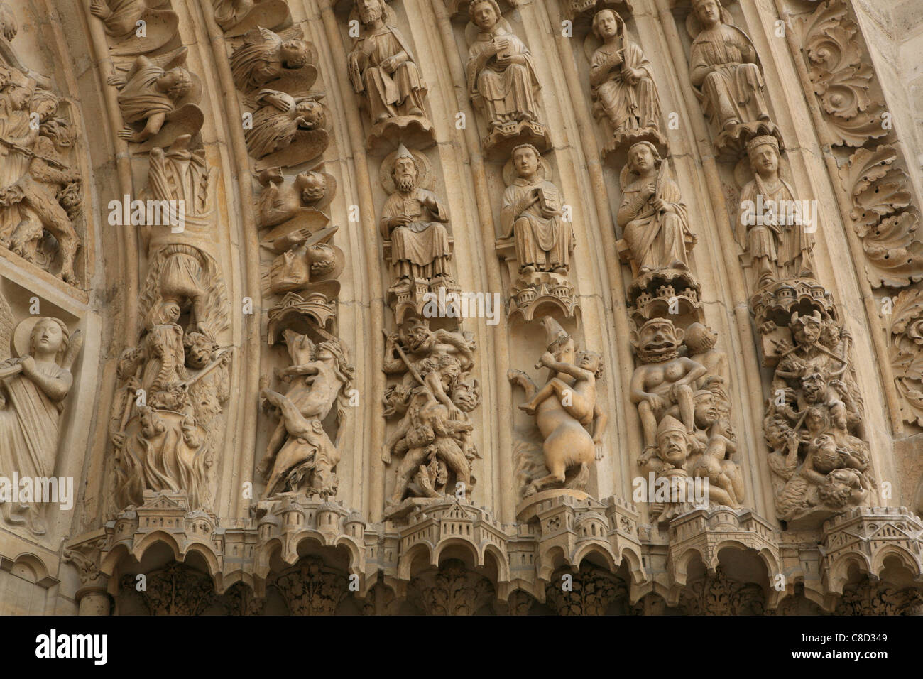 Punishment of sinner by the Devil. Gothic statues at the portal of the ...