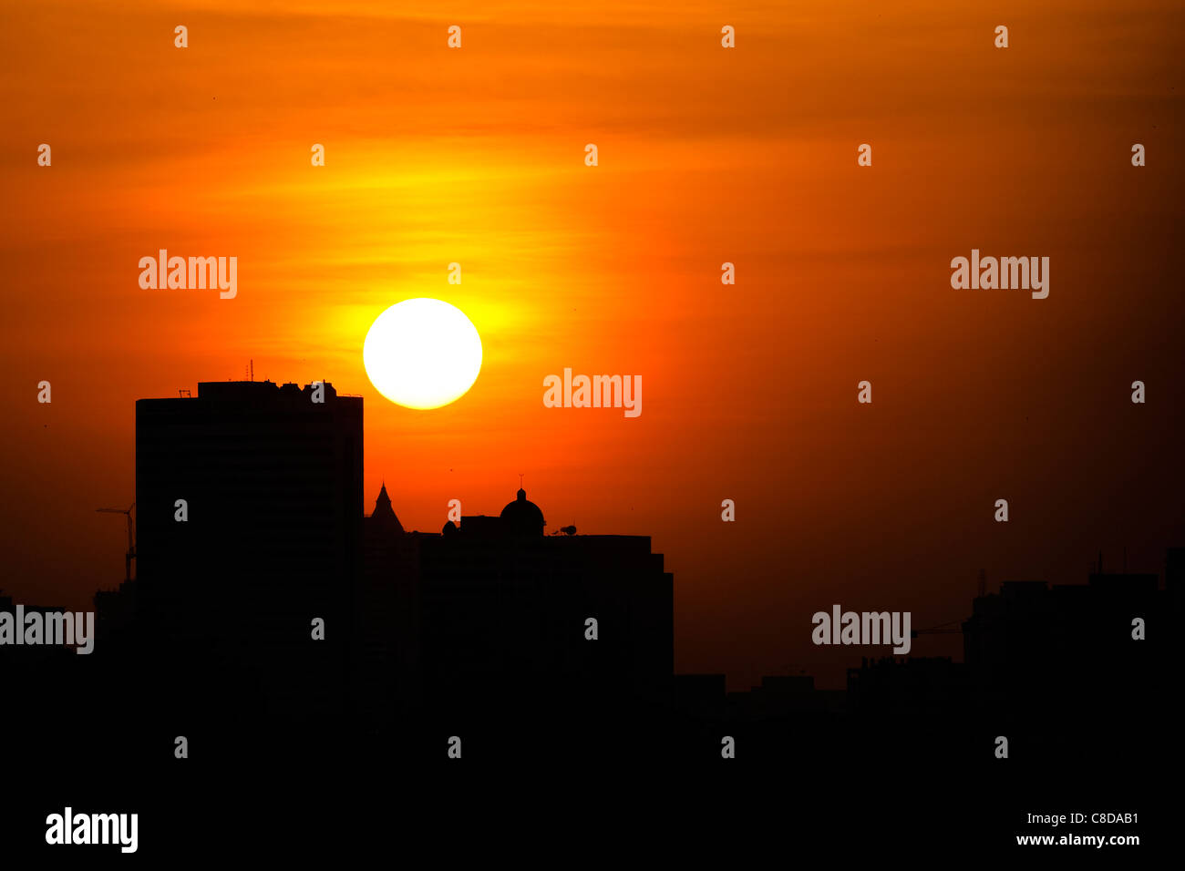 Picture of buildings with sun setting in the background Stock Photo - Alamy